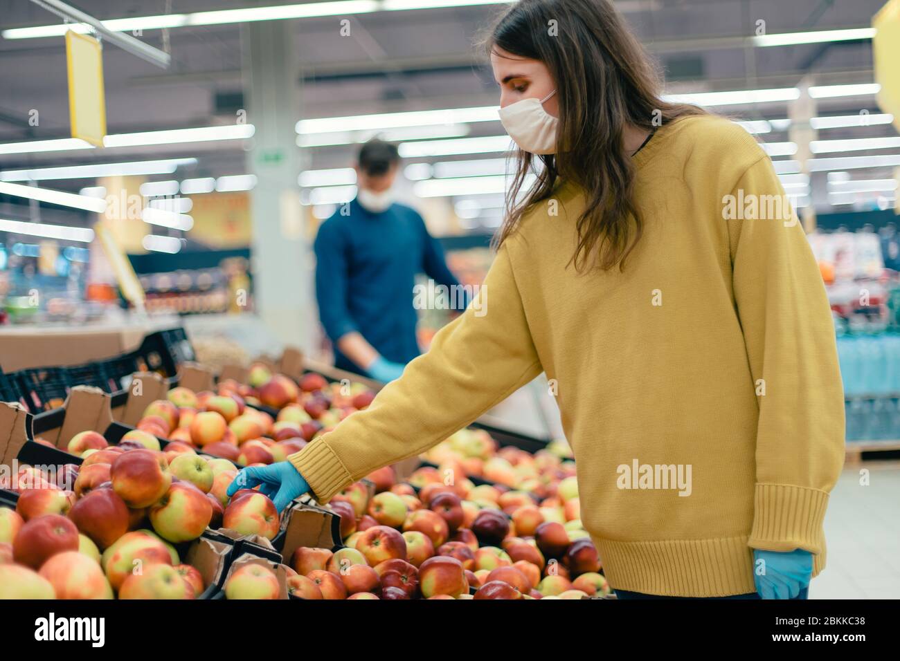 casual woman in protective gear buying fruit during the quarantine ...