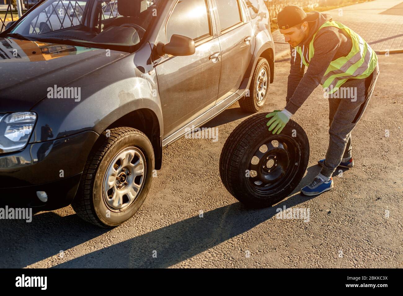 The driver should replace the old wheel with a spare. Man changing ...