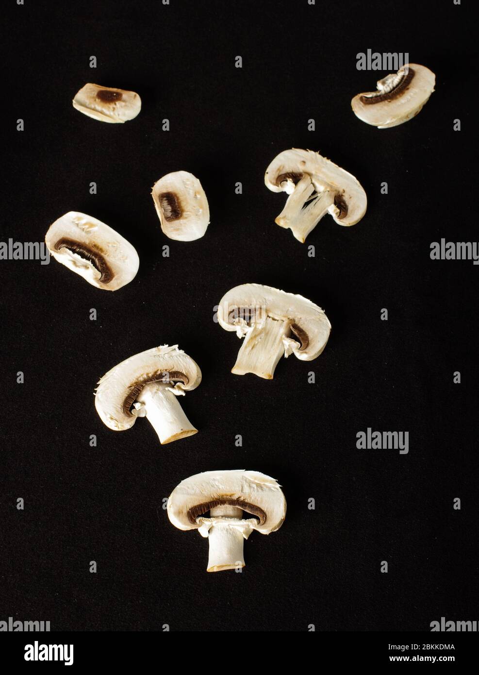 Raw champignon mushroom slices on the dark background Stock Photo - Alamy