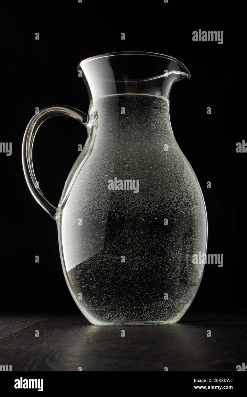 Glass water tank with small bubbles fully filled isolated on the black ...