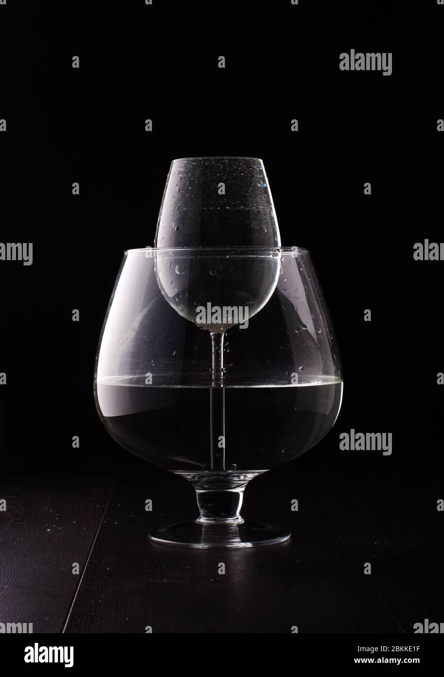 Wine glass in bigger wine glass isolated on the black background Stock ...