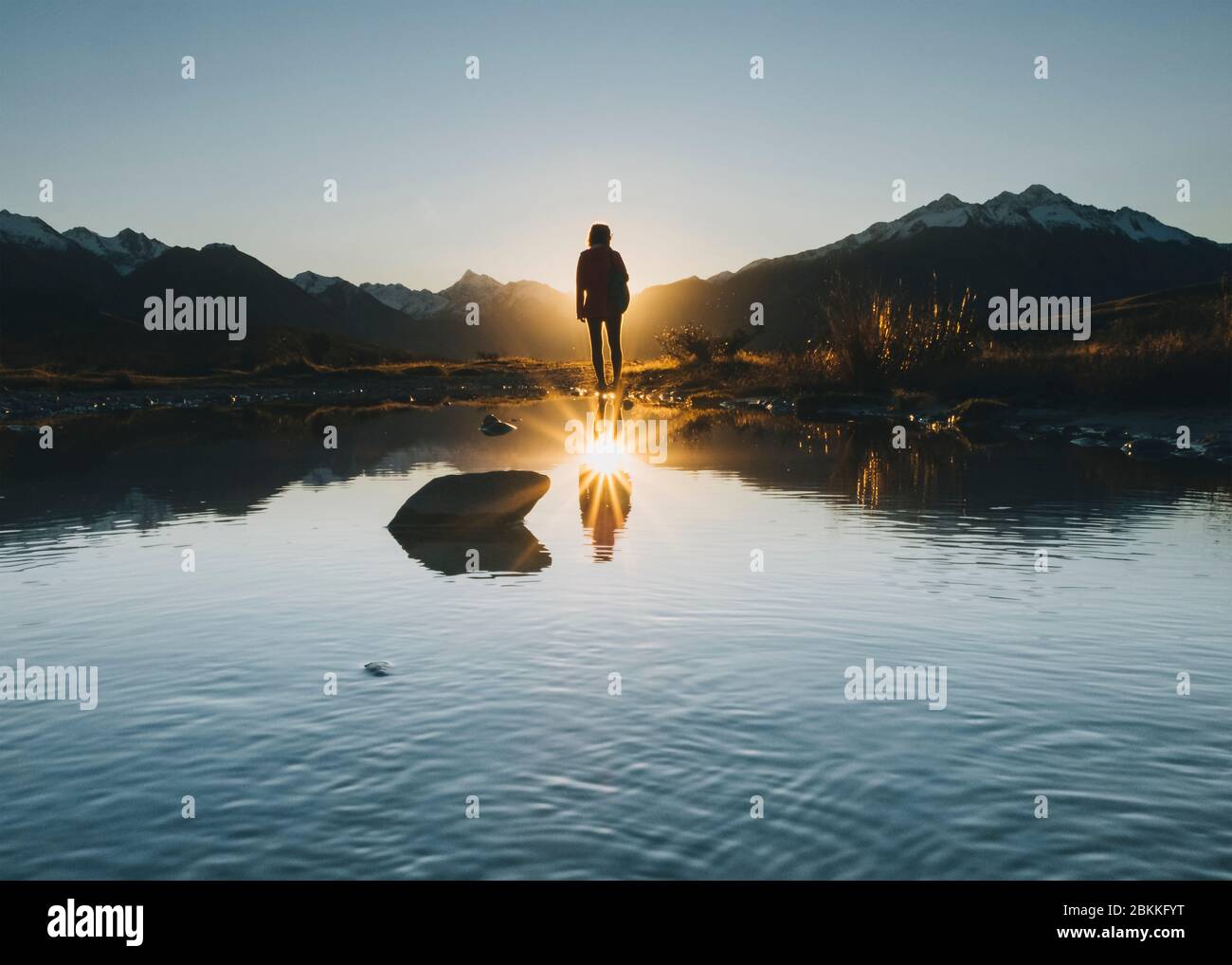 A young woman stands in front of a puddle, Canterbury, New Zealand ...