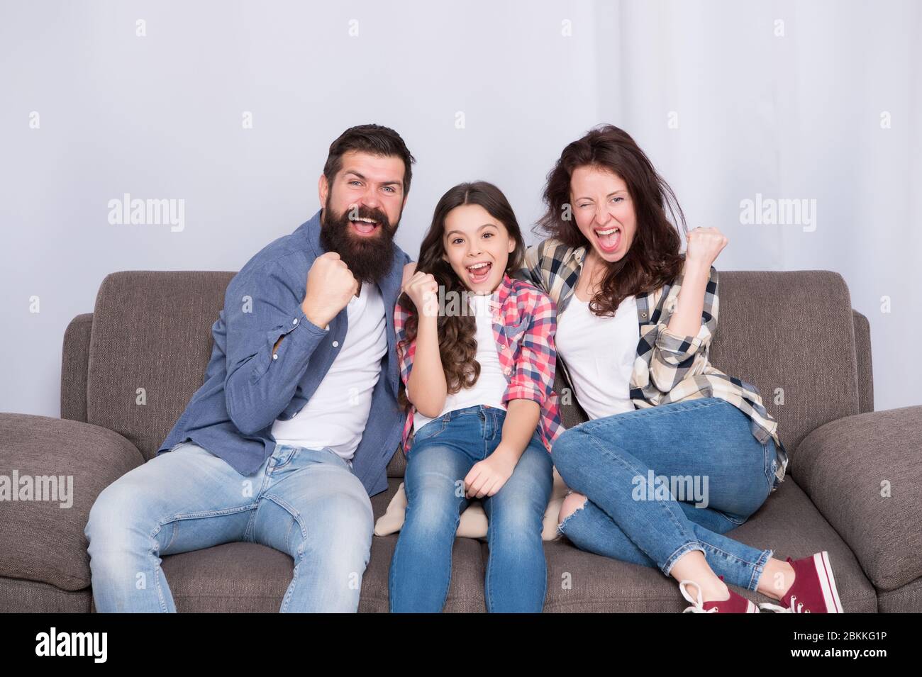 Stay at home. Family sit on couch. Happy father mother and daughter ...