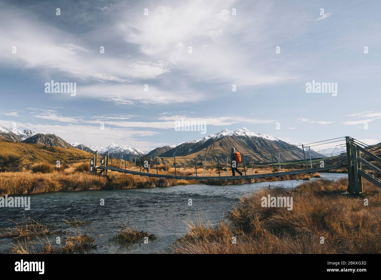 A young man hikes towards the summit of Mt Sunday, Southern Alps ...