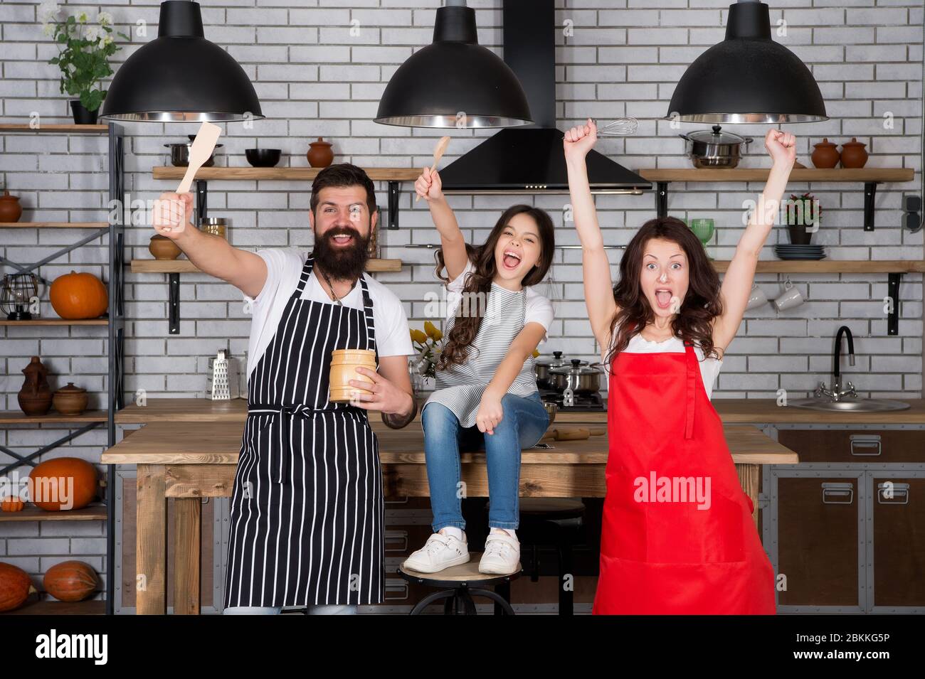 Friendly family. Mother father and daughter cooking together. Tasks and ...