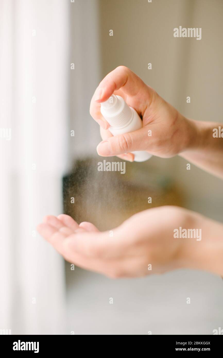 Hand spray. The woman is cleaning her hands with disinfectant spray. M ...