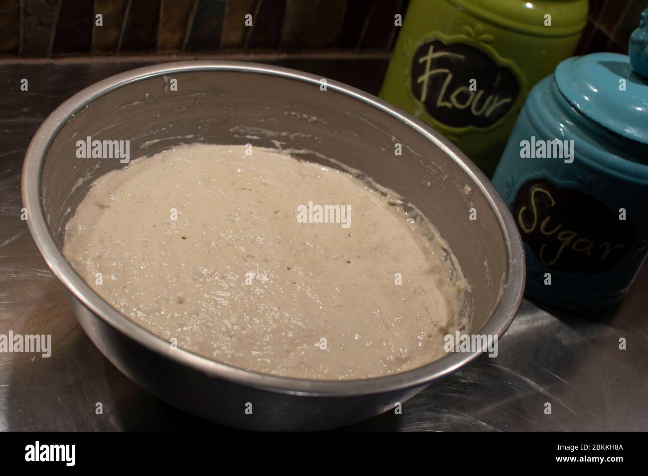 A bowl of risen dough right before its second rise. In a steel bowl ...