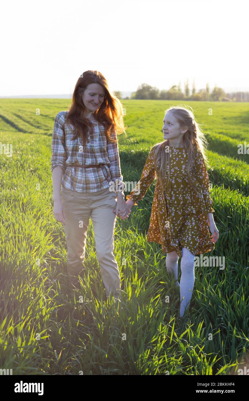family - happy mother and daughter walk on the field at sunset Stock Photo - Alamy