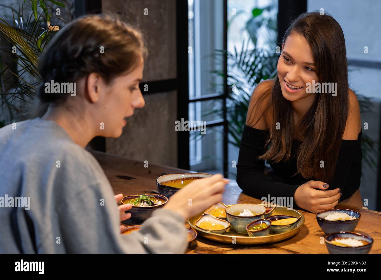 Two young pretty girls having a nice time in a cafe Stock Photo - Alamy