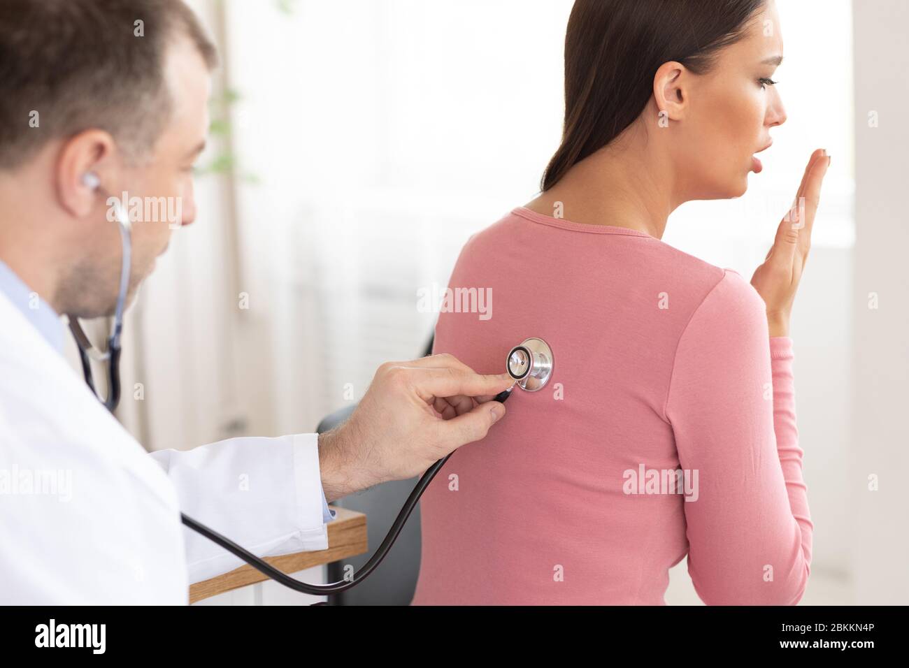 Experienced doctor checking breath of female patient Stock Photo - Alamy