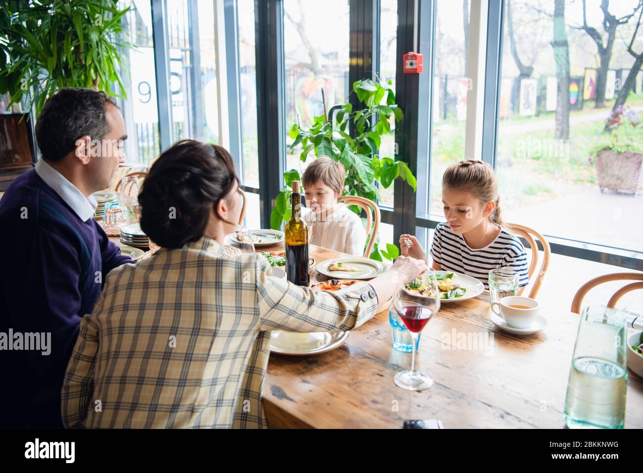 A young family with kids in a cafe, the parents are drinking wine Stock ...