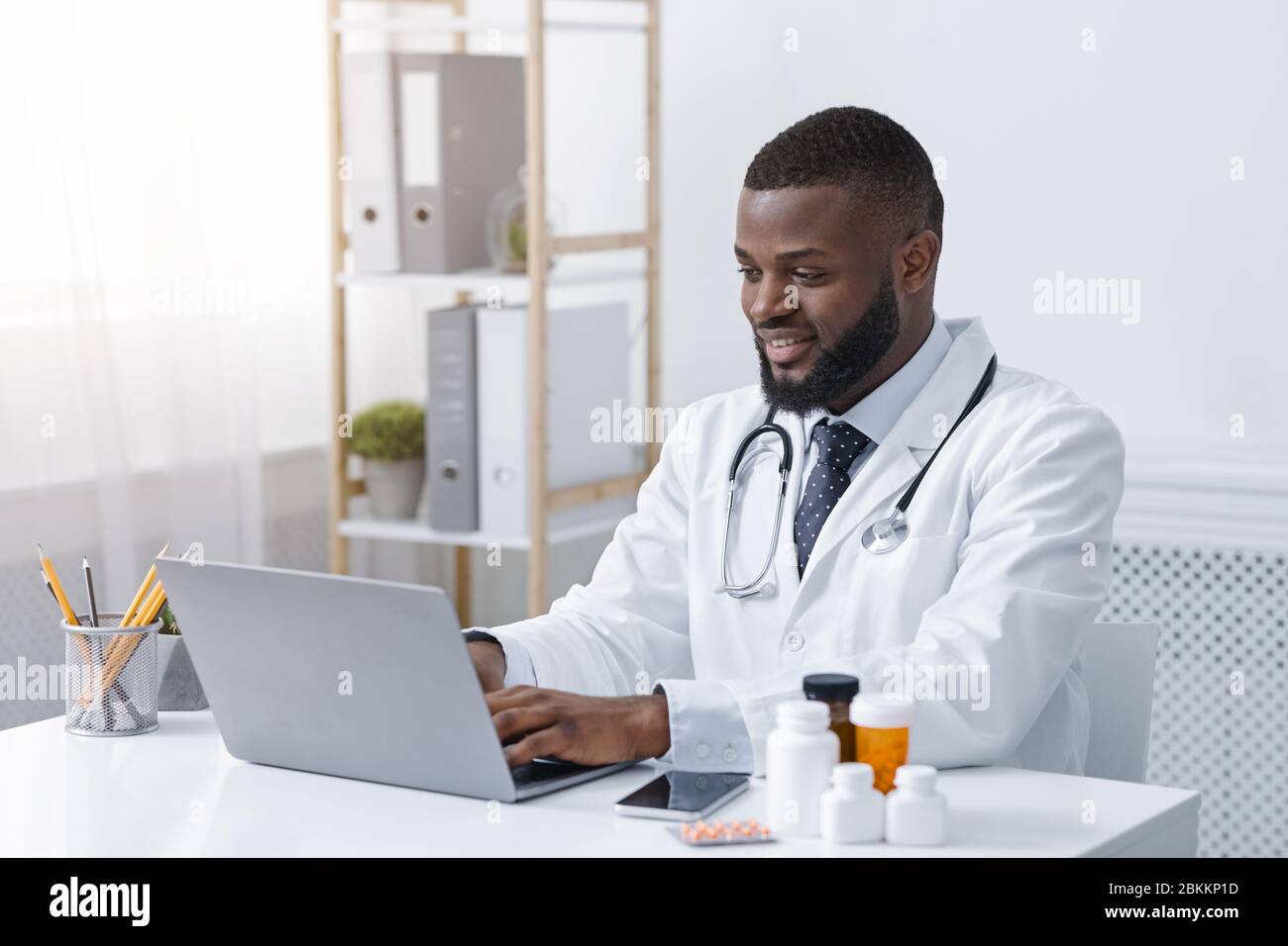 Black man doctor typing hi-res stock photography and images - Alamy