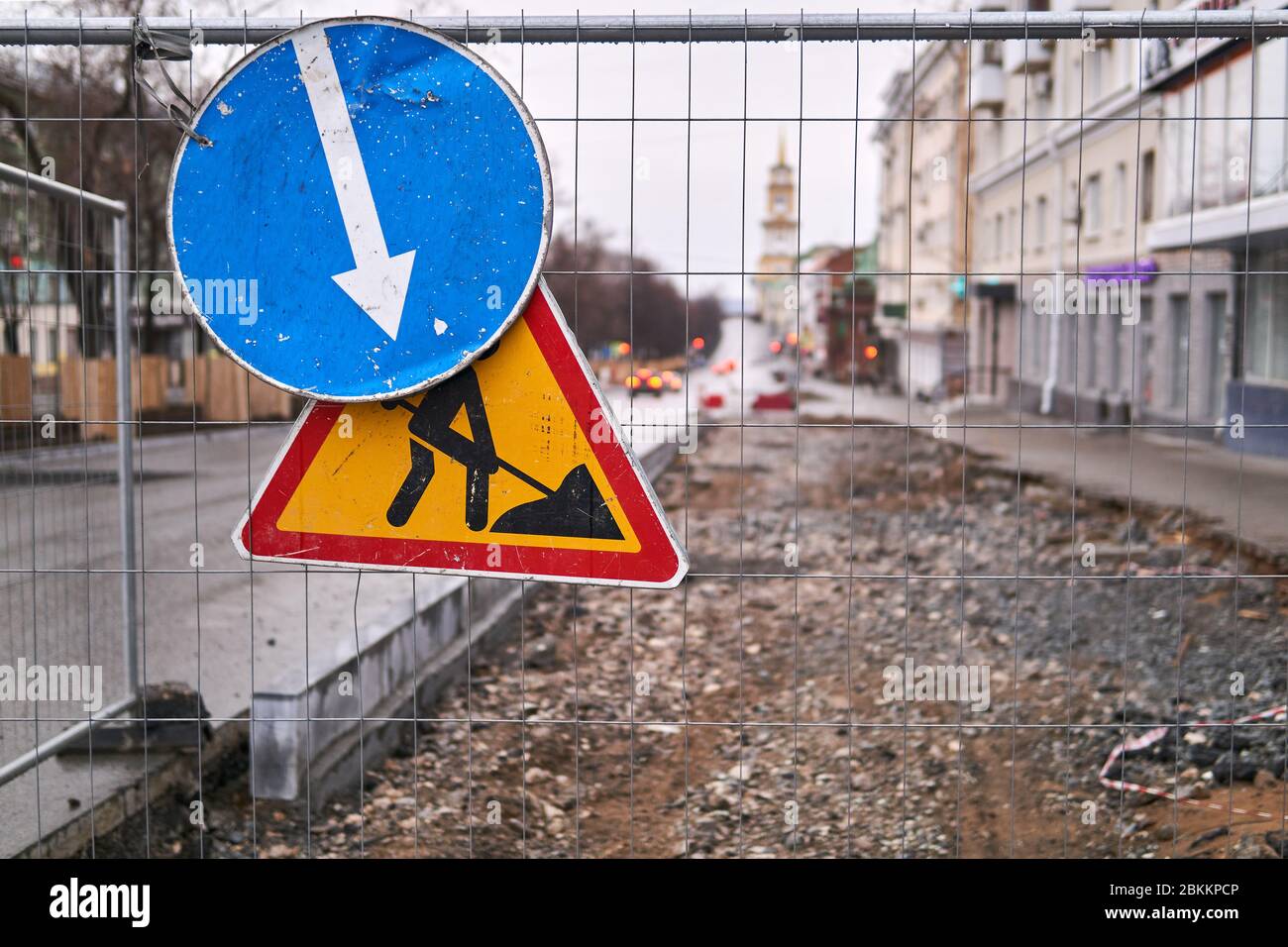 road signs Roadworks ahead and Pass on this side on the fence in front ...