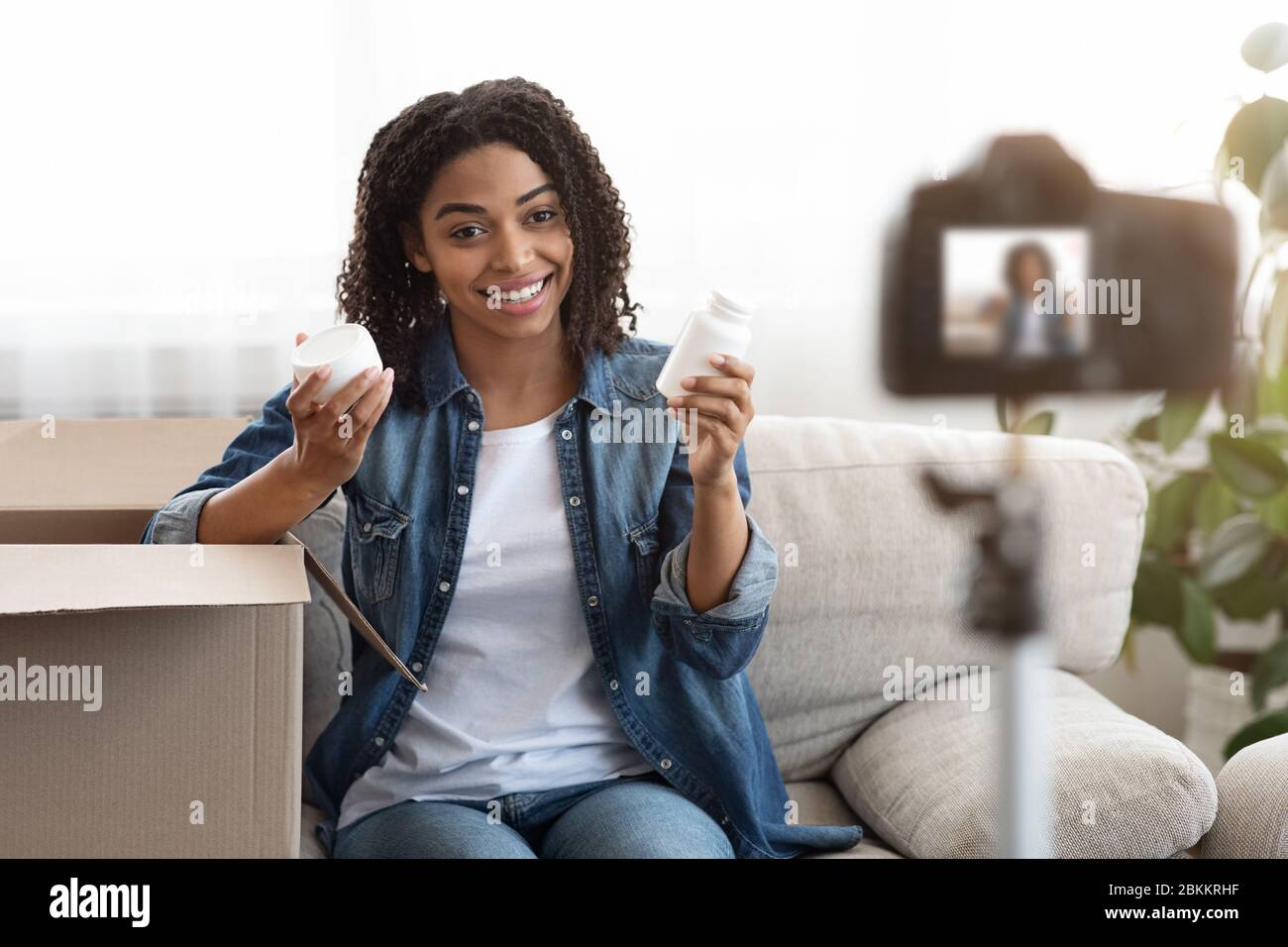 Beauty blogger. Black girl vlogger recording cosmetic review video at ...