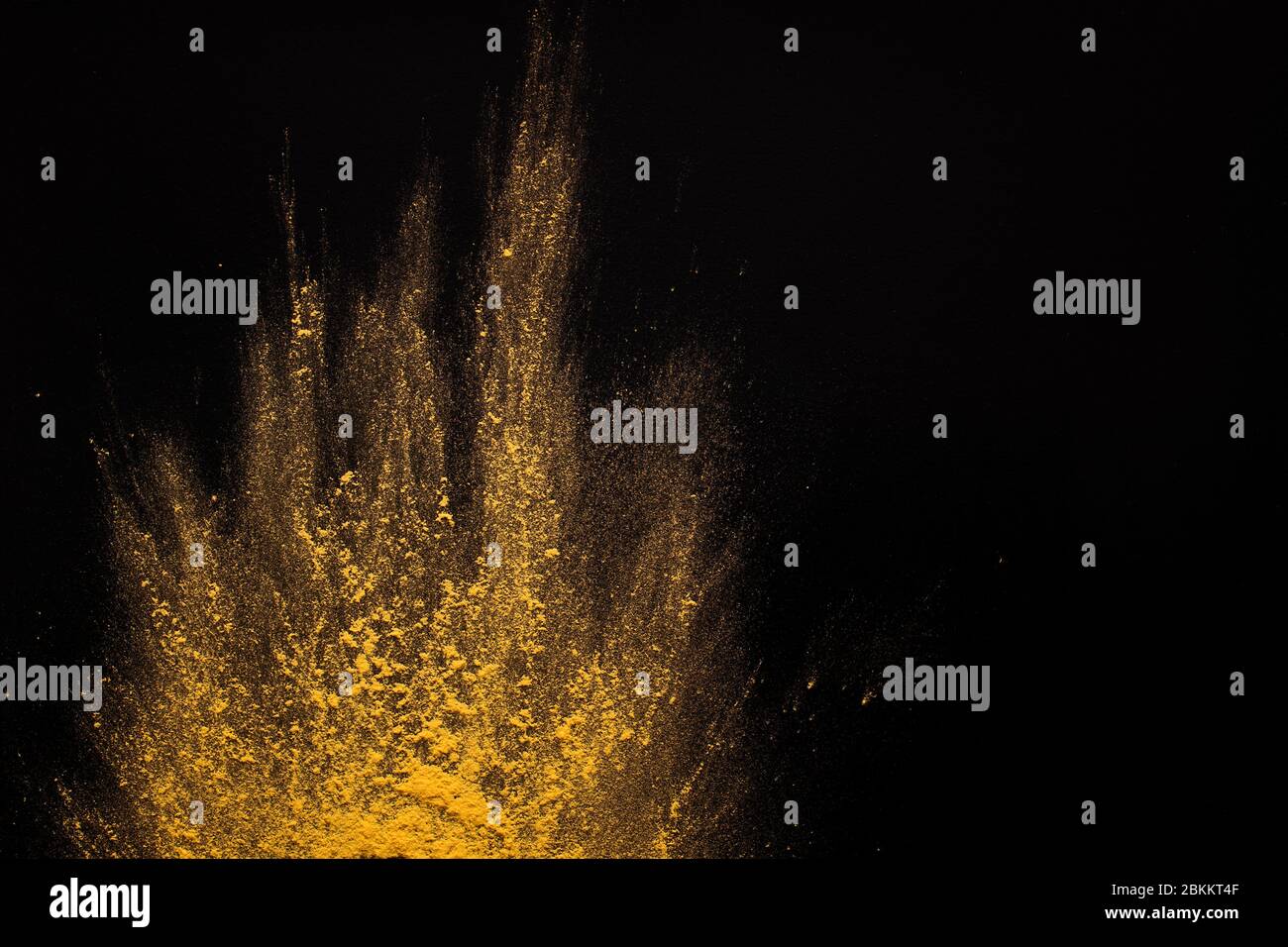 Cloud of yellow paint scattered on black background Stock Photo - Alamy