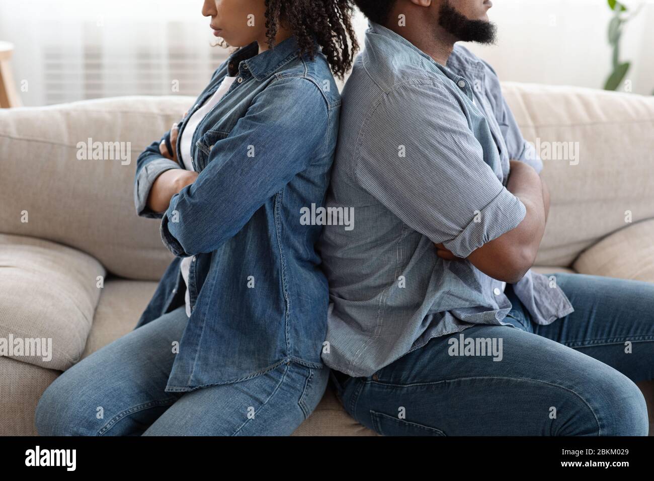 Stubborn African Couple Sitting Back To Back On Couch After Quarrel