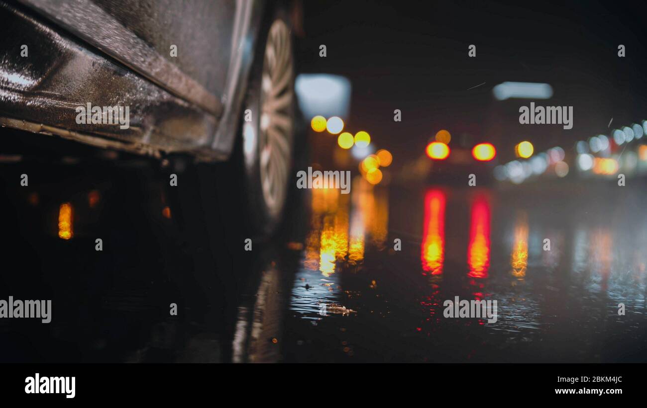 Black car on the wet rainy road at night. Mid shot Stock Photo - Alamy