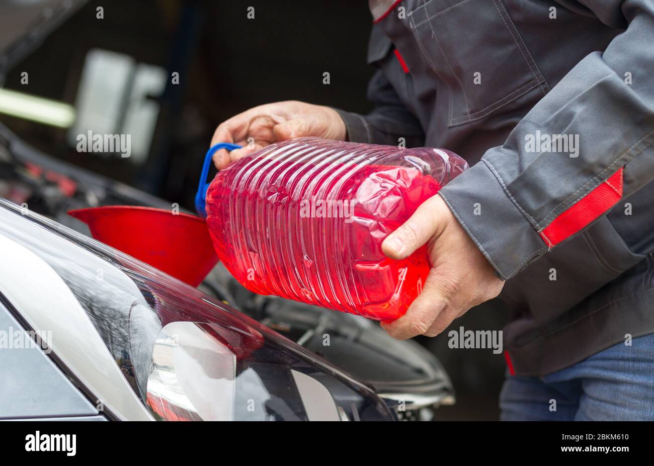 Replacing fluids in a car mechanic Stock Photo - Alamy