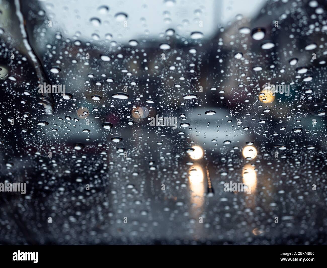 Water drops on windshield with blur car headlight on the street in ...