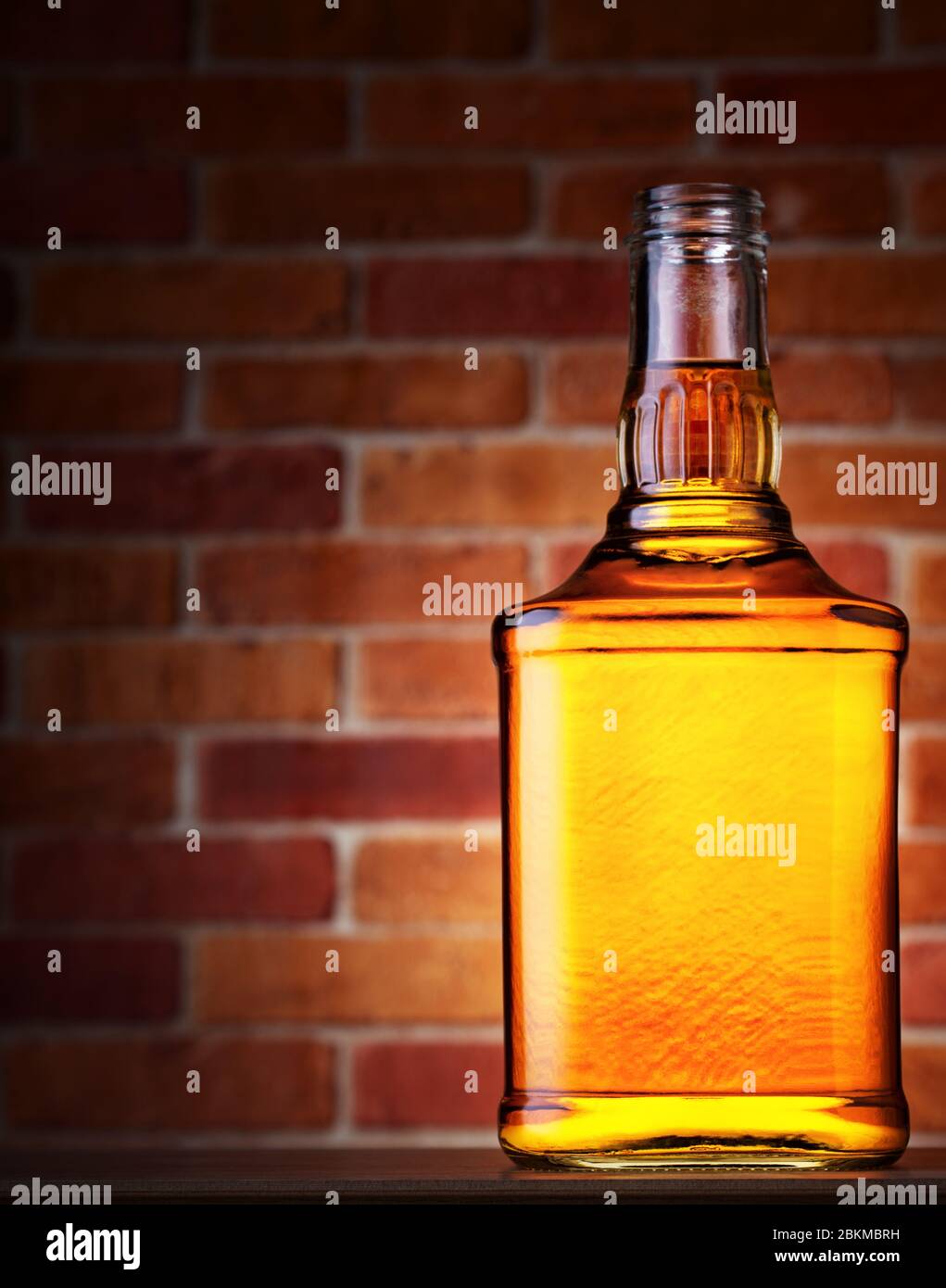 Open bottle of whiskey or brandy on brick wall background Stock Photo ...