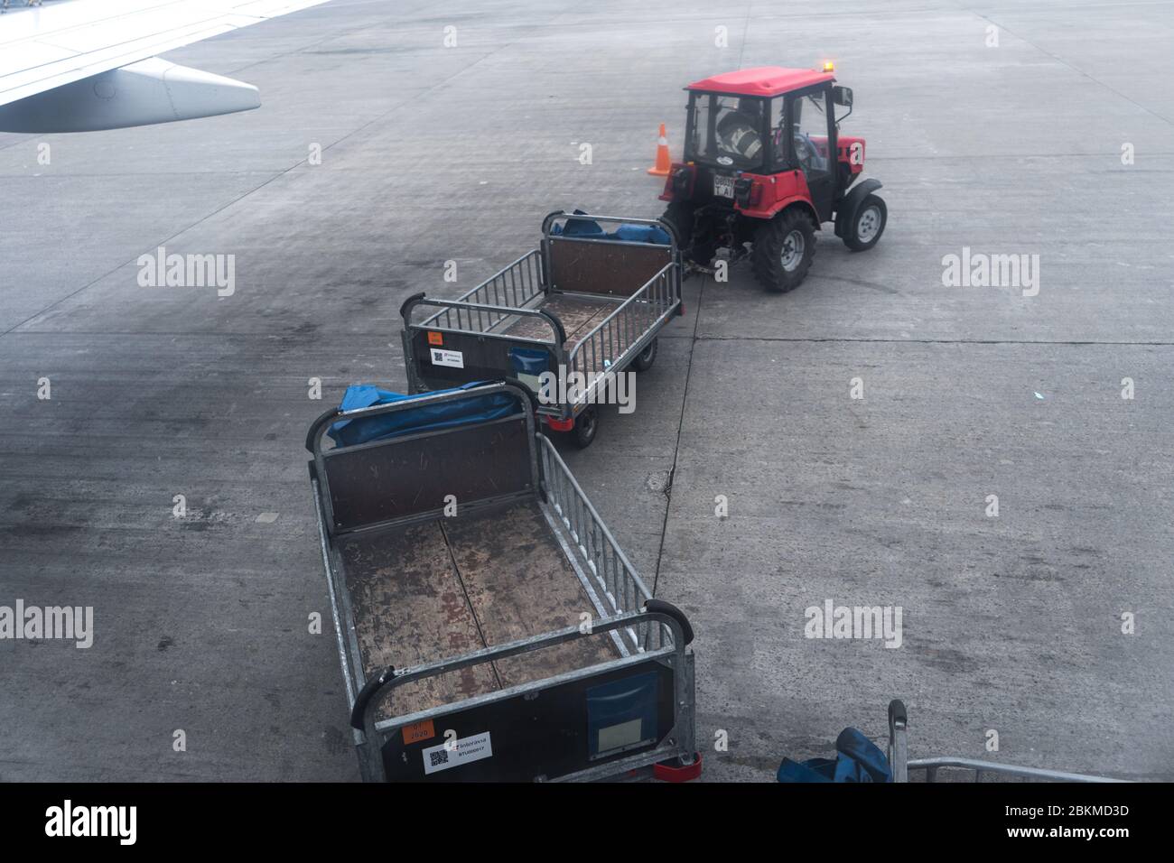 a tractor with a trailer for transporting passenger luggage between an ...