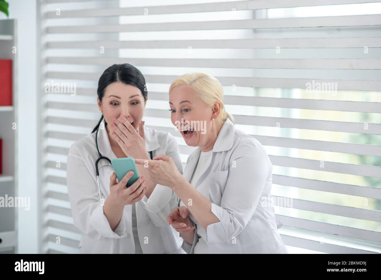 Two doctors in white robes laughing together Stock Photo - Alamy