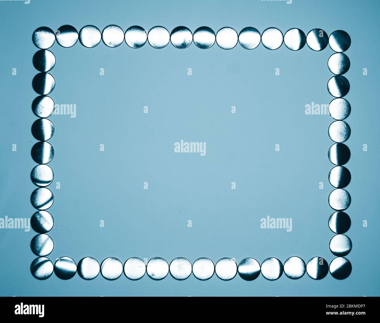 rectangular frame made of round metal caps on blue background Stock ...