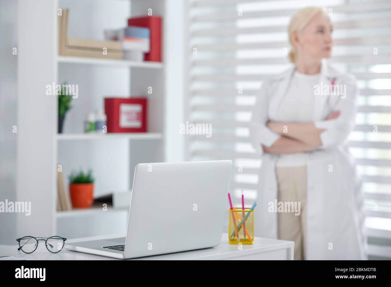 Workplace of a female doctor who is standing near window Stock Photo ...