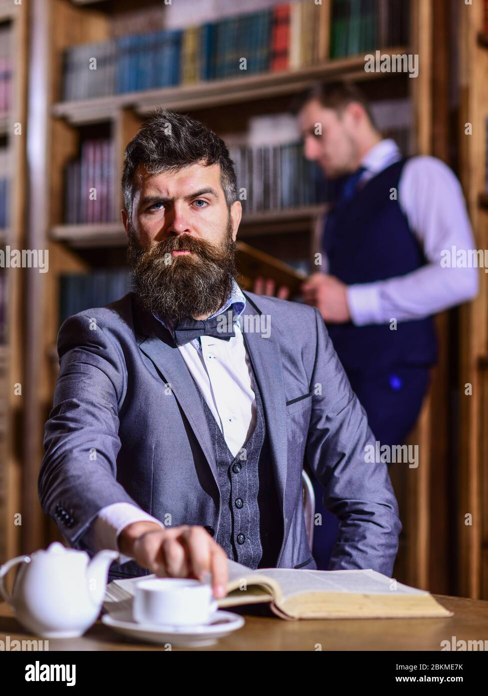 Man with beard and strict face at tea party. Retro detectives work on ...