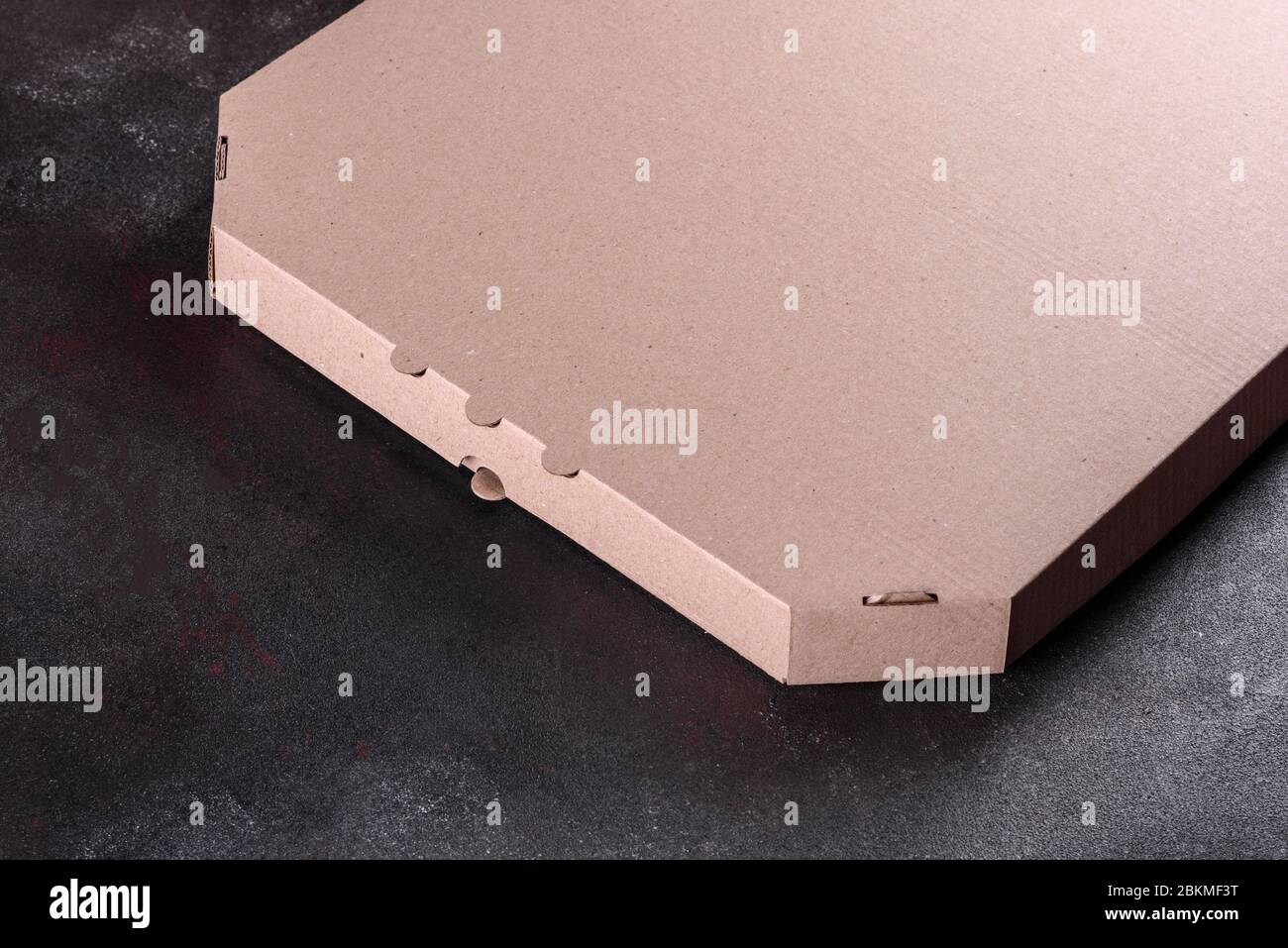 Box for delivery of delicious Italian pizza on the dark table of the ...