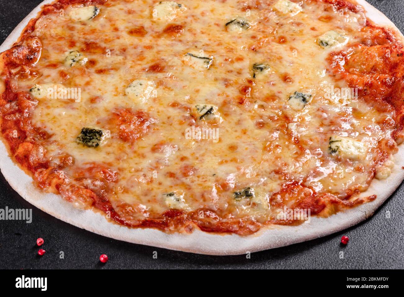 Delicious fresh oven cooked pizza four cheeses on cozy restaurant table ...