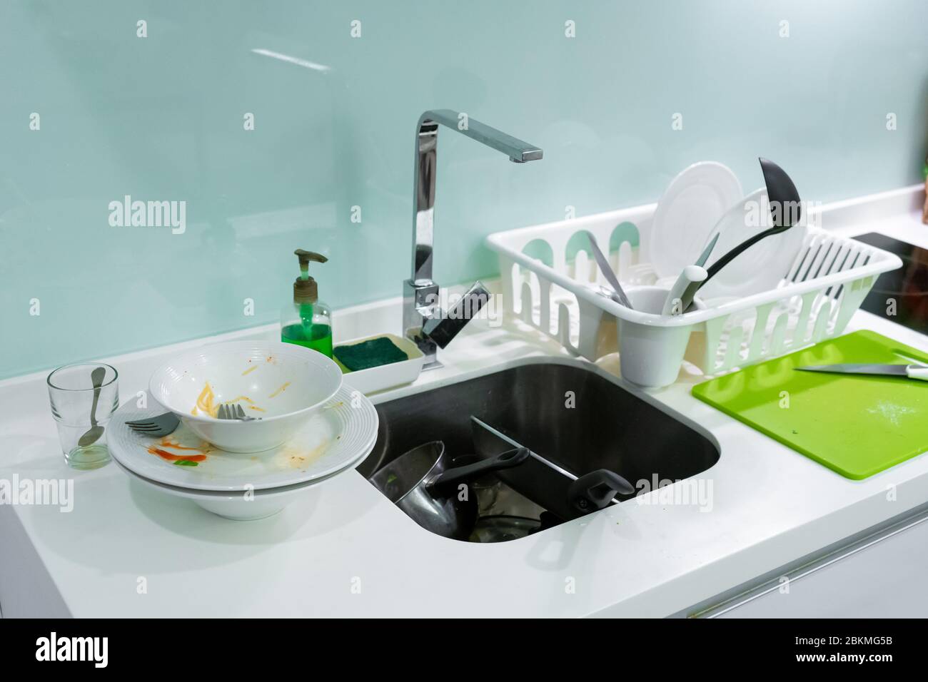 A mountain of dirty dishes in the kitchen sink. Mess in the house Stock ...