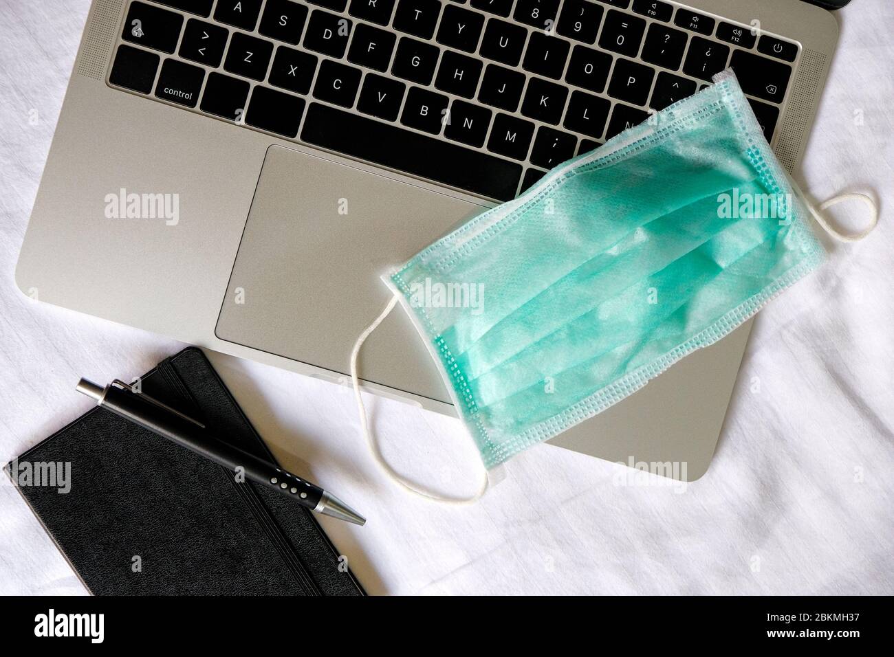 Operating room mask on a laptop computer along with a notebook and a ...