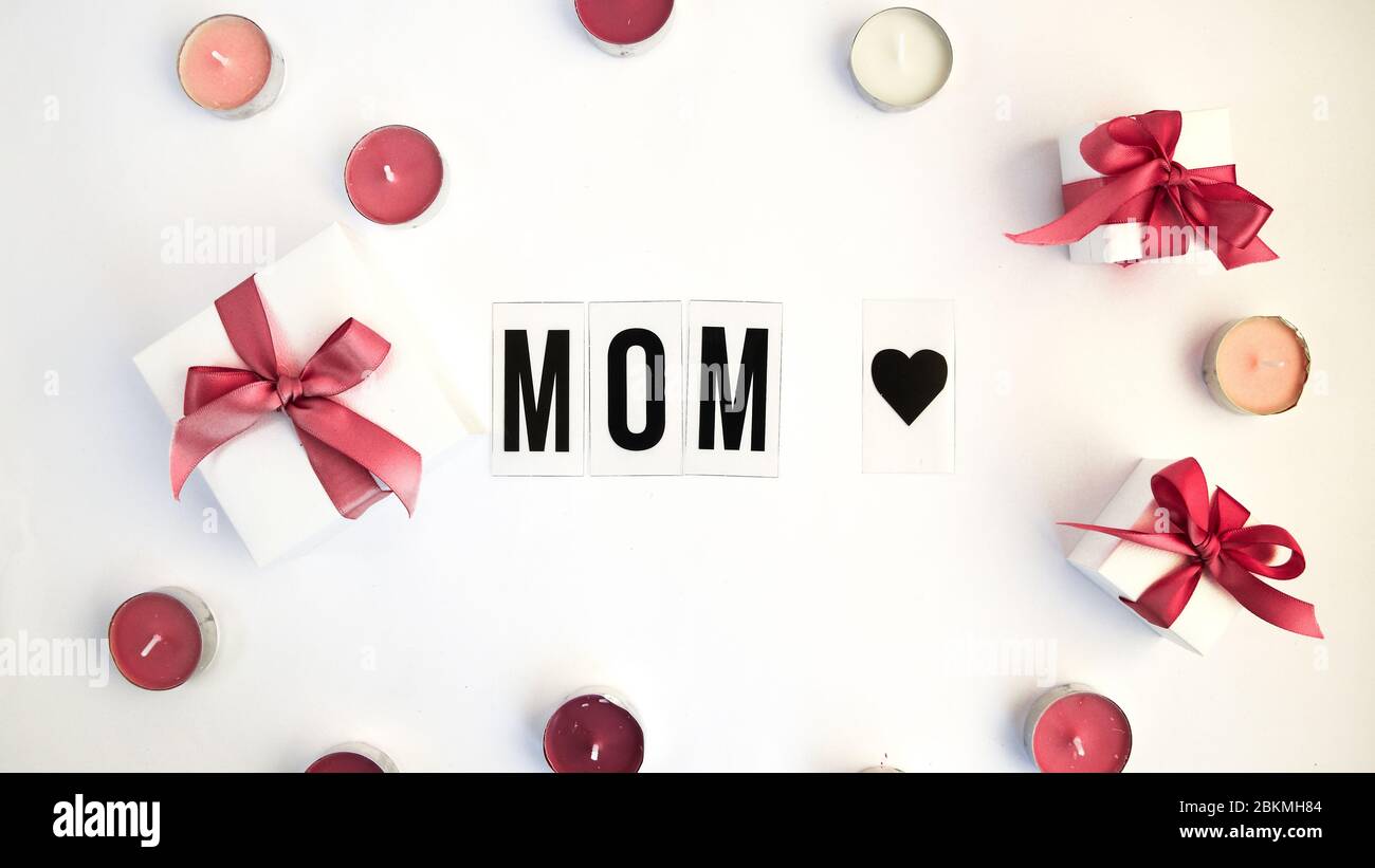 MOM text on white table background, with gift boxes and candles Stock ...