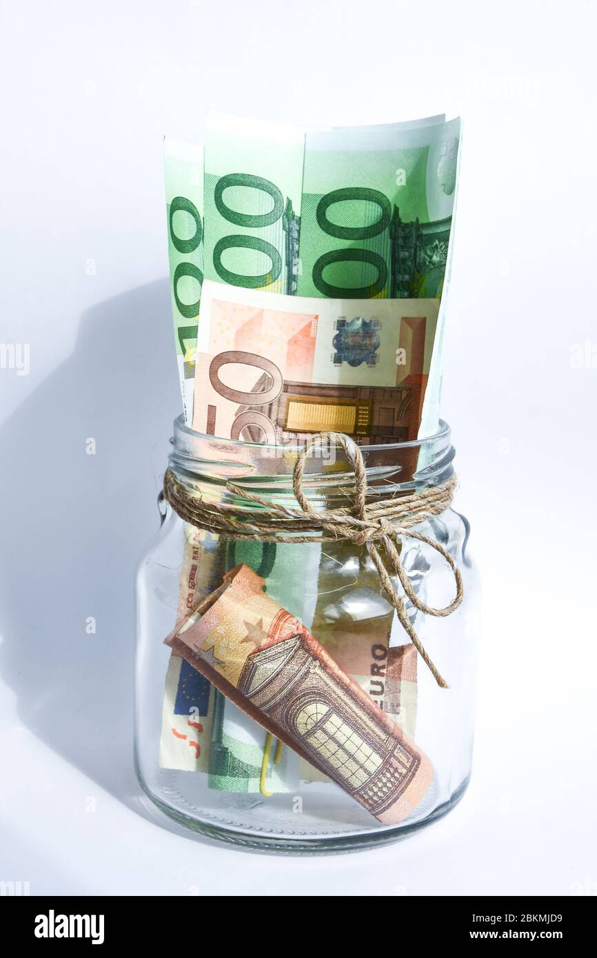 Glass jars filled with coins and Euro bills, savings inside glass jar ...