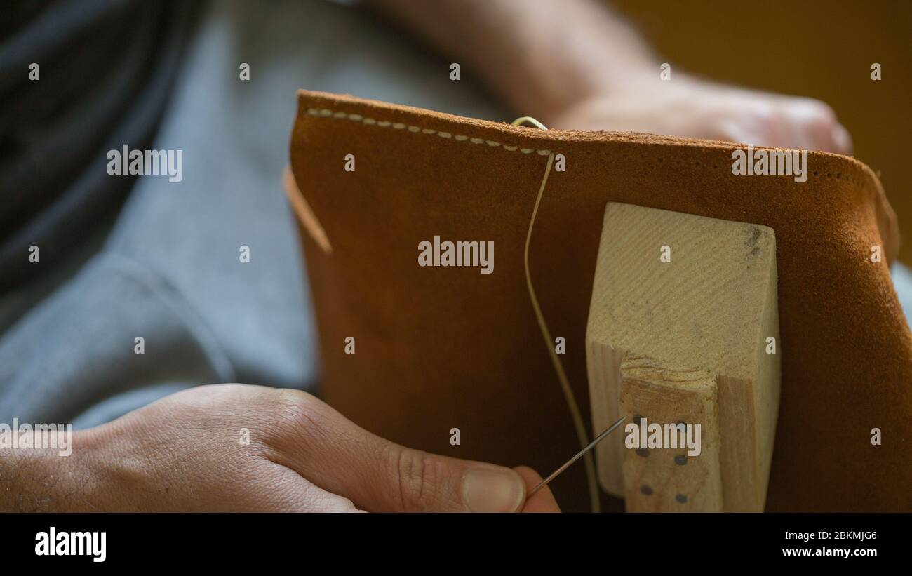 Handmade handicraft leather bag sewing process. Hands working leather ...