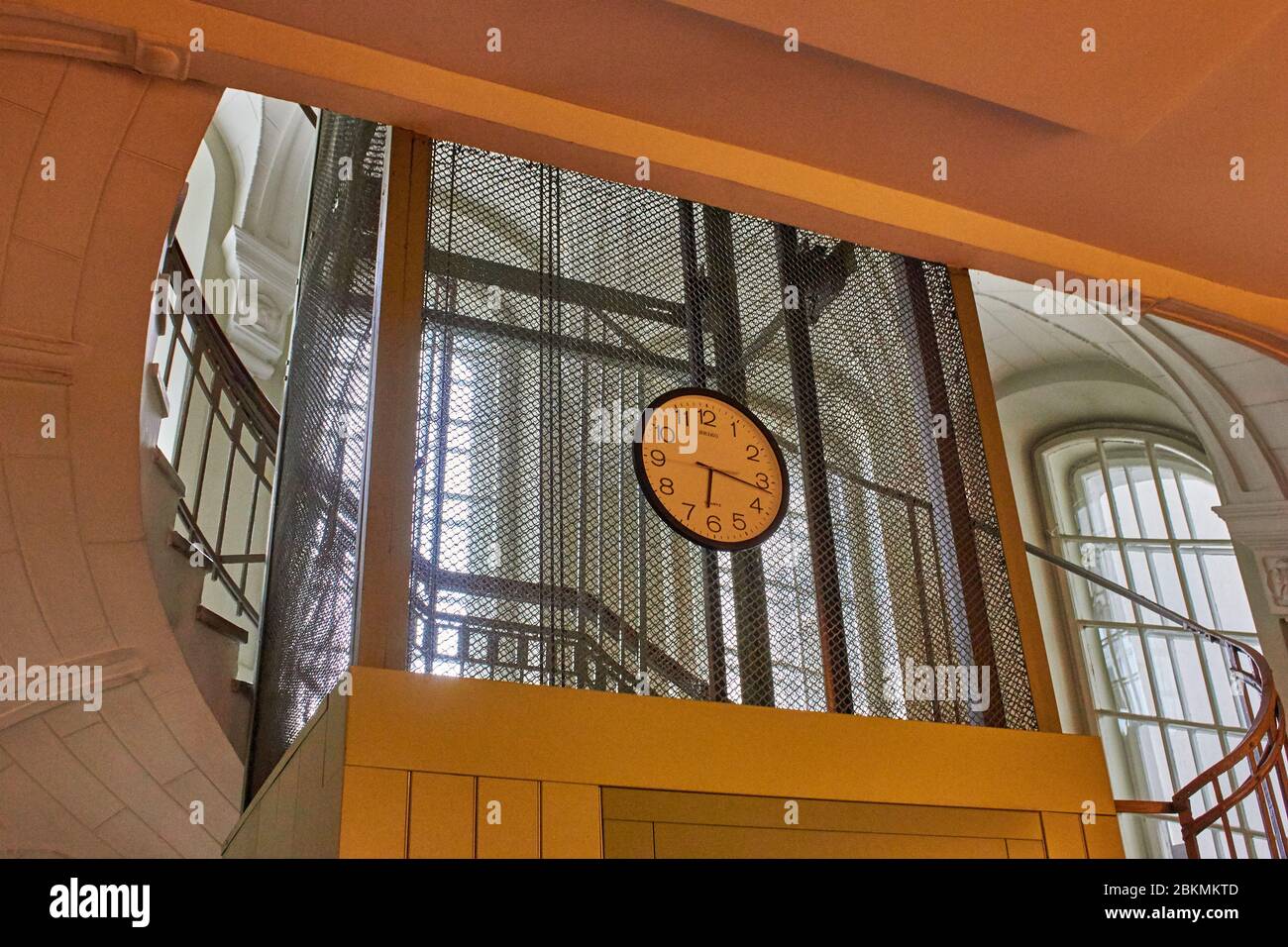Old style elevator with clock on it's protective net Stock Photo - Alamy