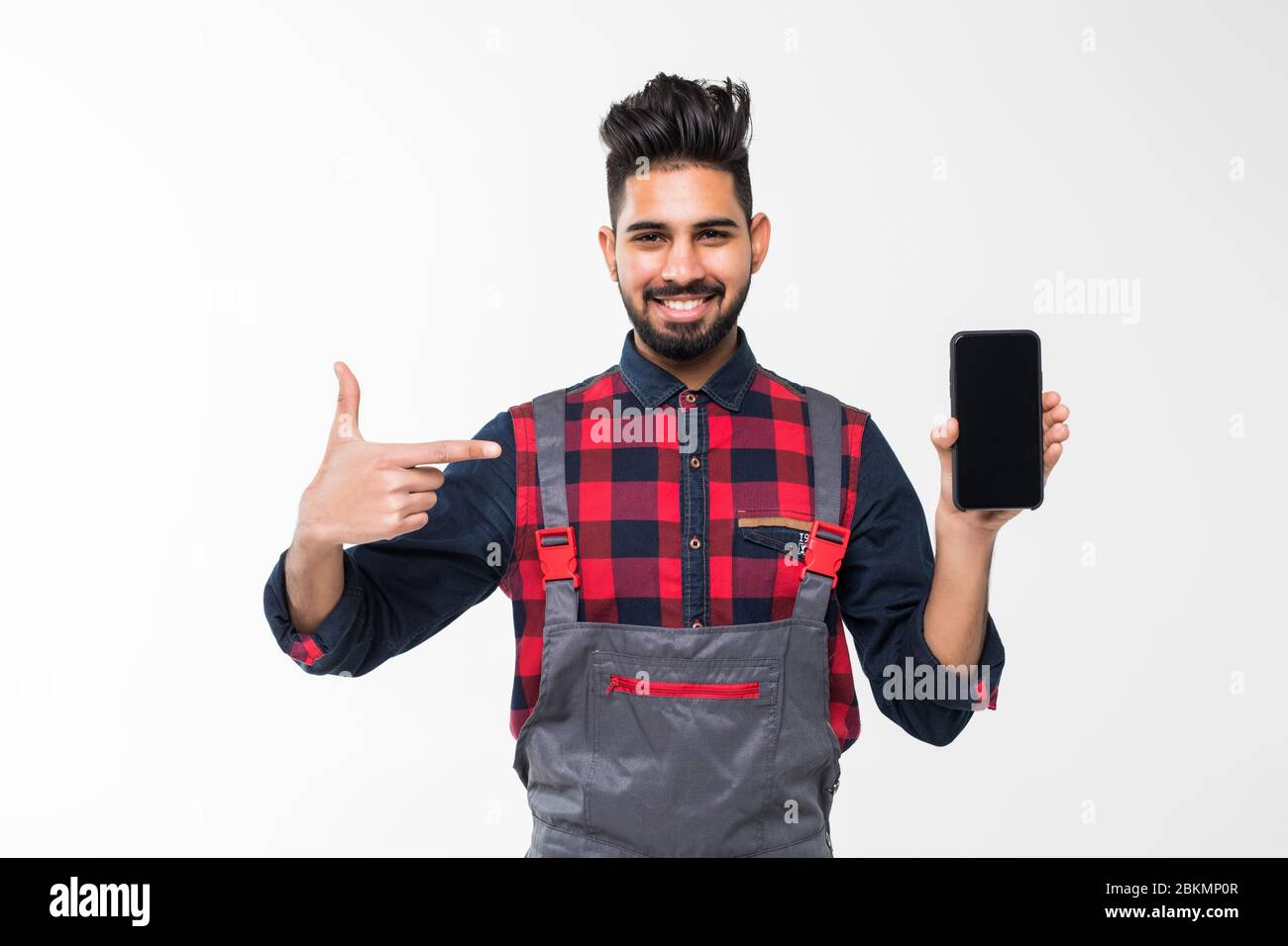 Portrait of smiling handyman showing mobile phone on white background ...