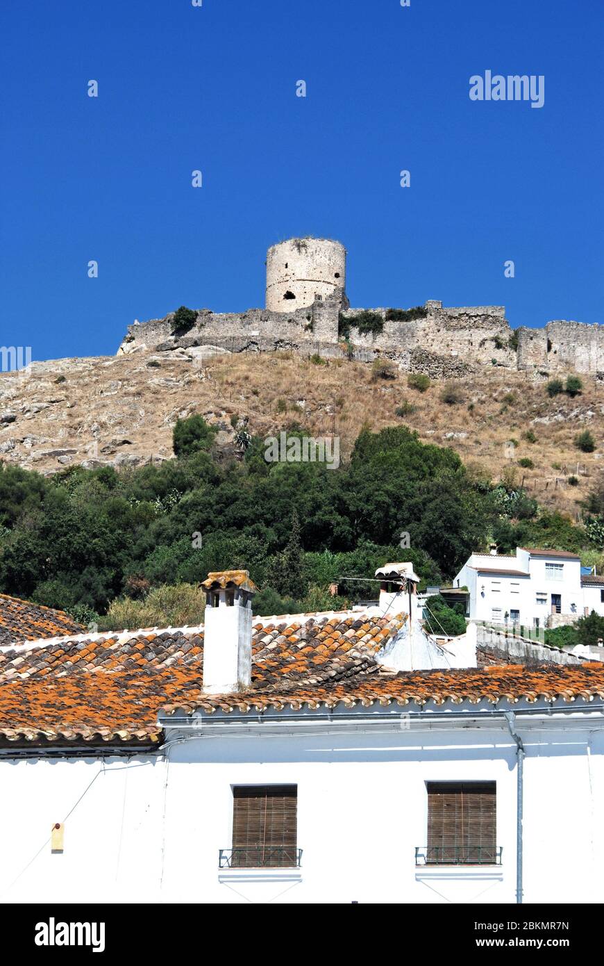 View of the castle above the village rooftops, Jimena de la Frontera ...