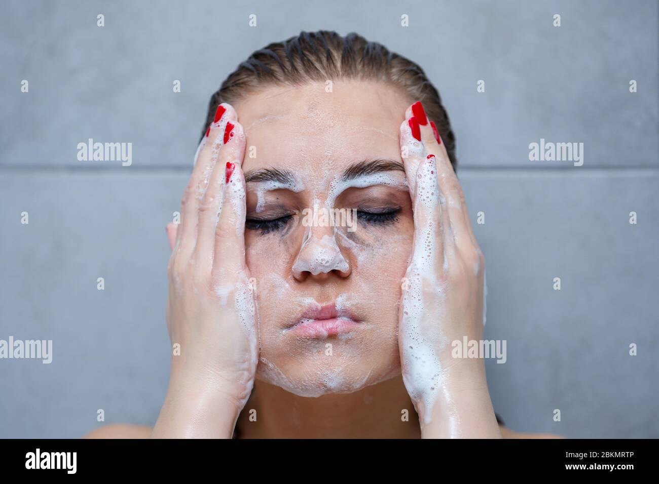 Face skin care. Woman applying facial cleanser on face closeup. Girl ...