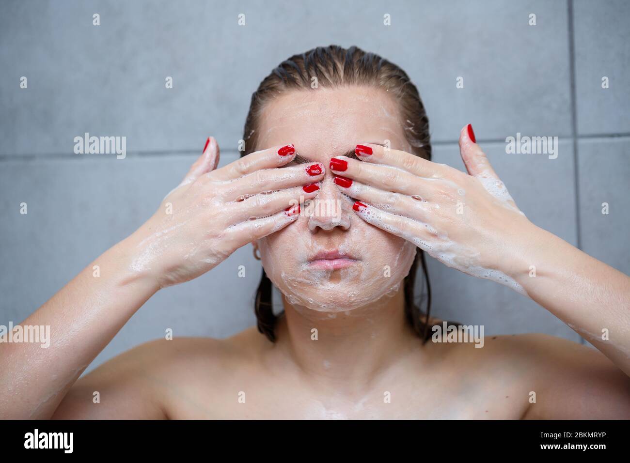 Face skin care. Woman applying facial cleanser on face closeup. Girl ...