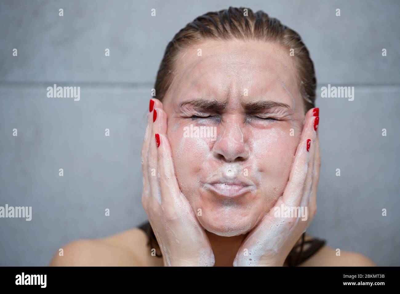 Face skin care. Woman applying facial cleanser on face closeup. Girl ...