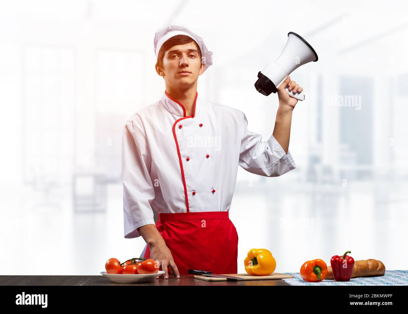 Young chef standing with megaphone in hand Stock Photo - Alamy