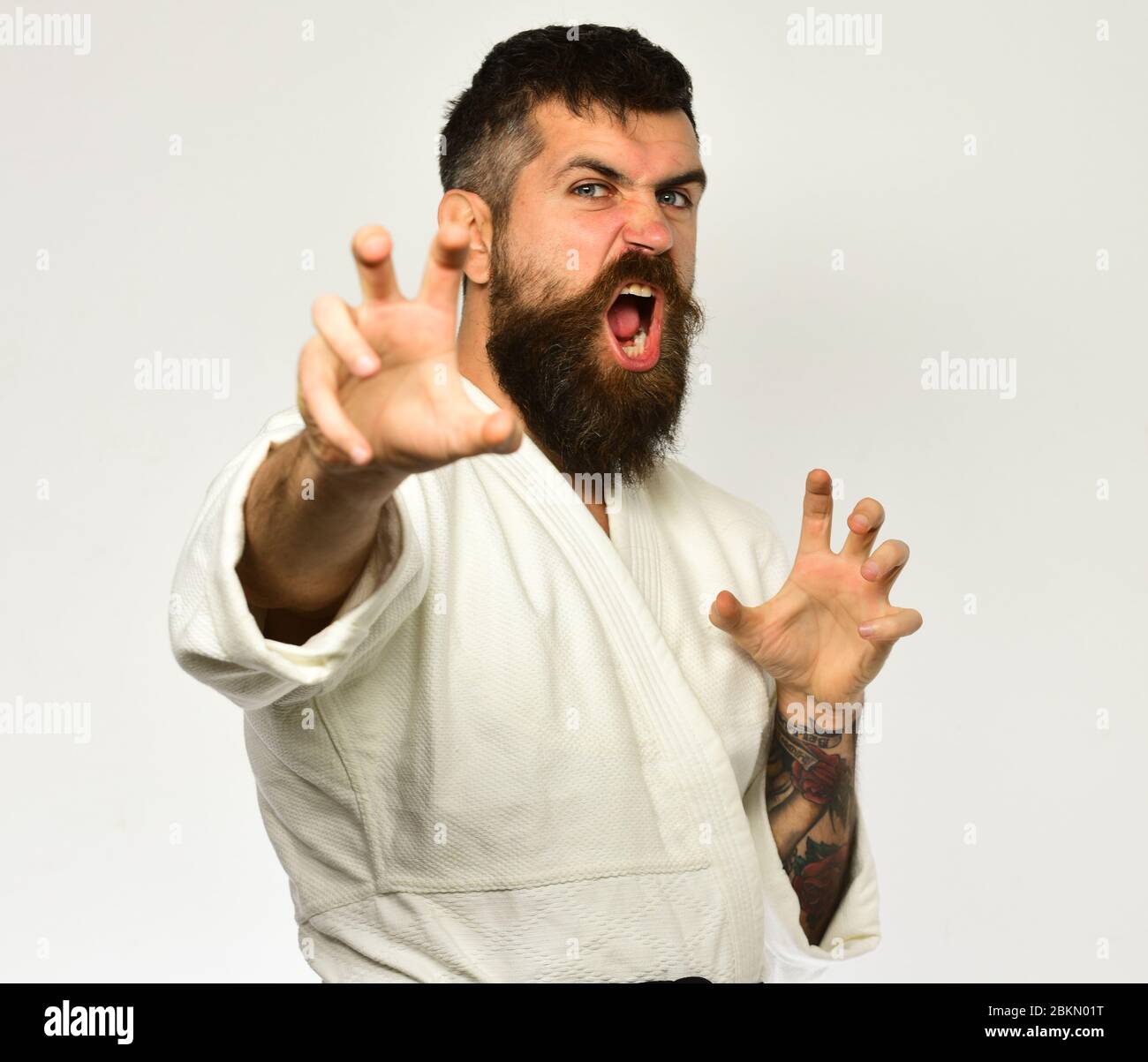 Judo master with black belt practices attack or defense posture. Man ...