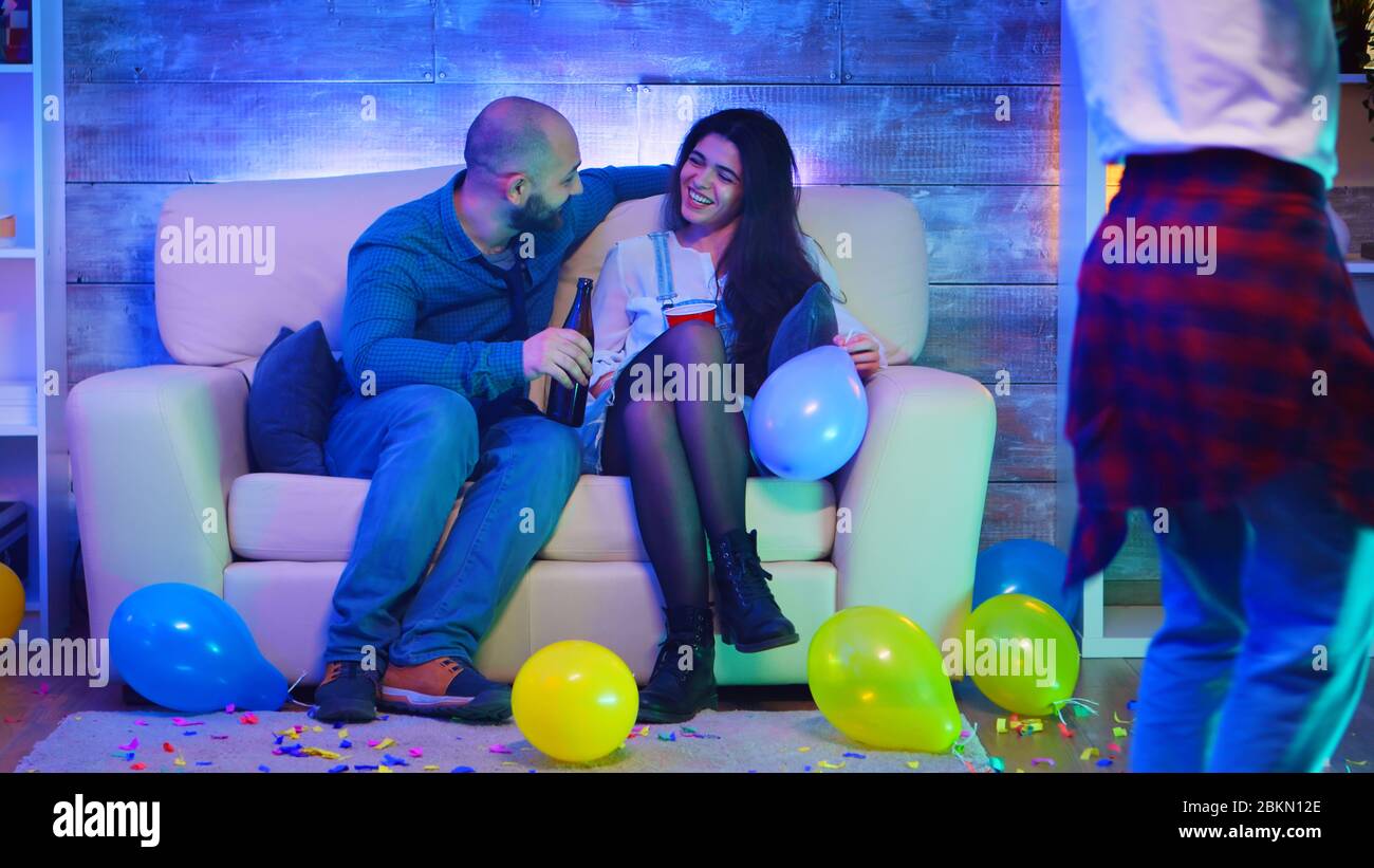 Handsome young man socializing with a beautiful girl at his friends ...