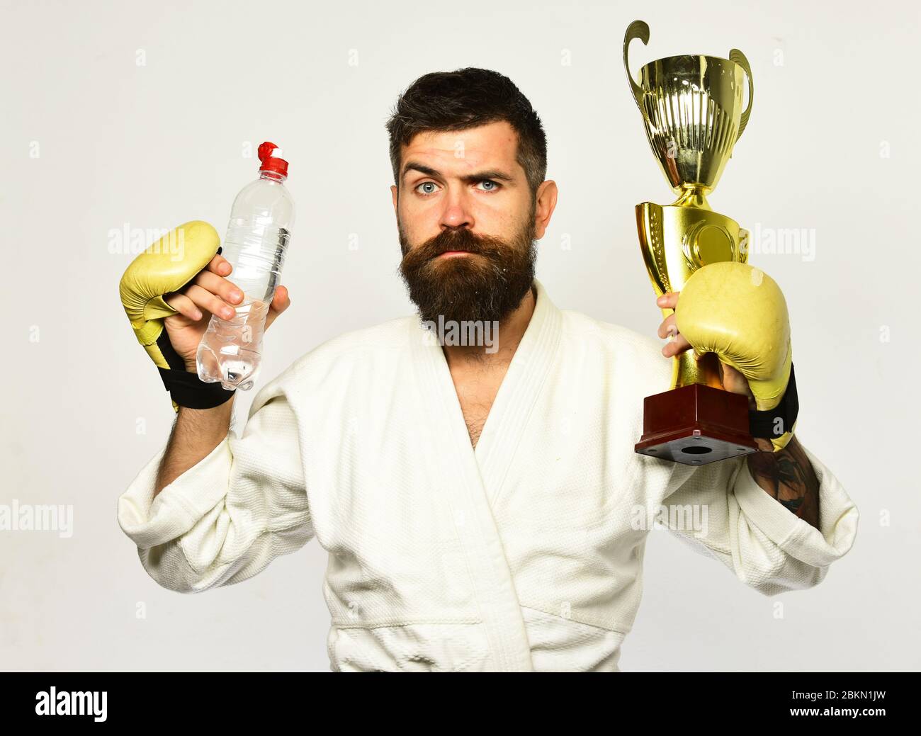 Man with beard in kimono on white background. Karate man with confused ...