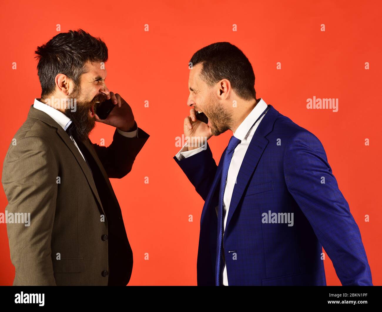 Men with beards stand face to face on red background. Businessmen with ...