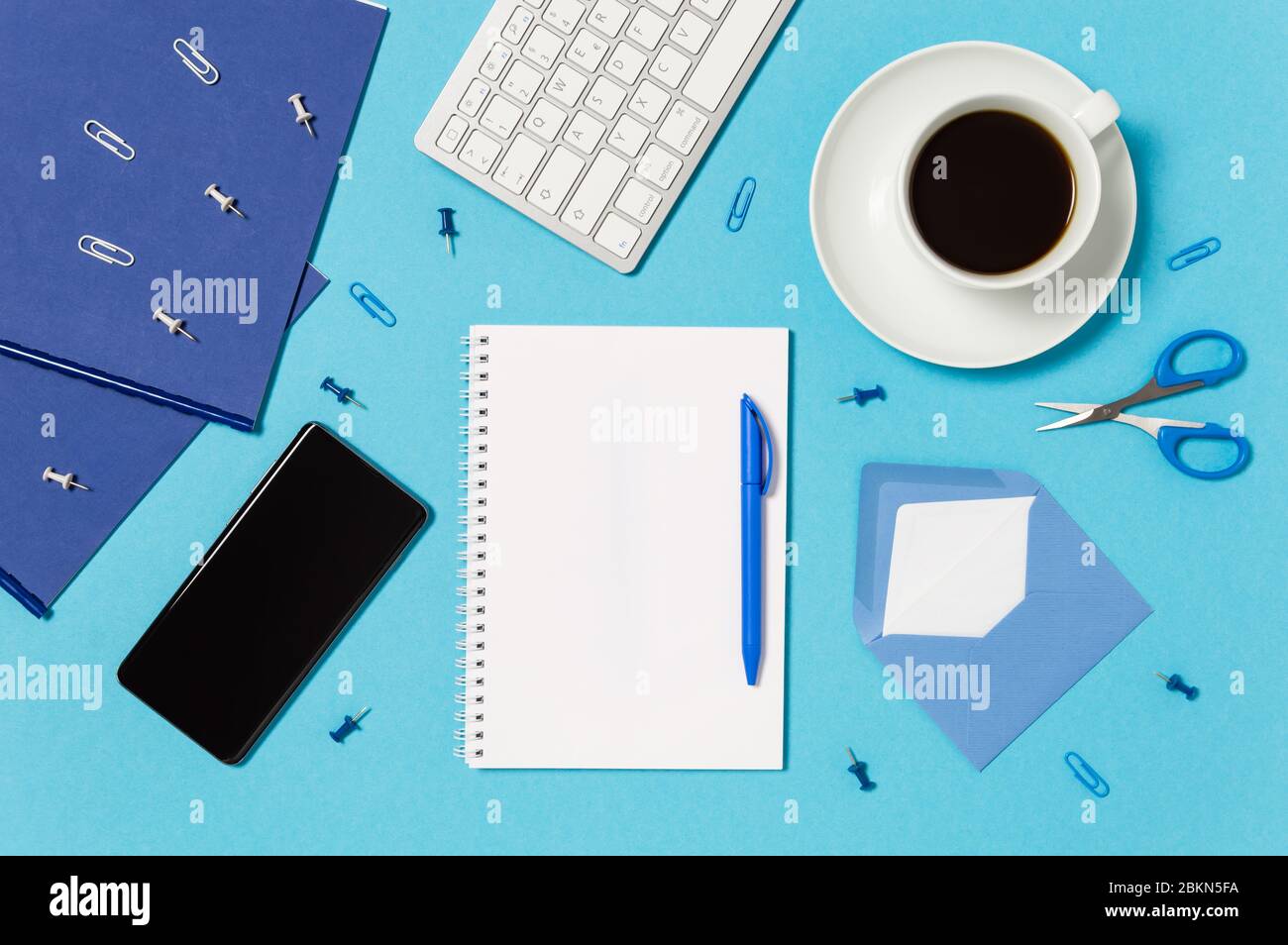 Creative workspace with keyboard, coffee cup, notepad, pen, mobile ...