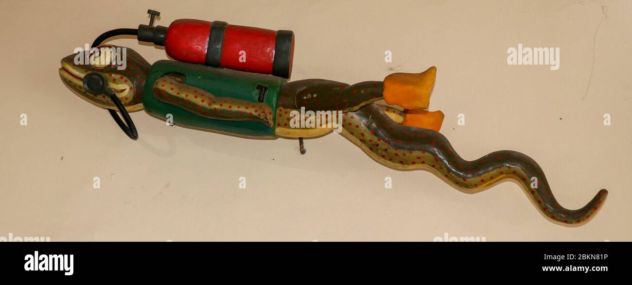 Statue of gecko with diving equipment on the wall of diving center. 3D ...