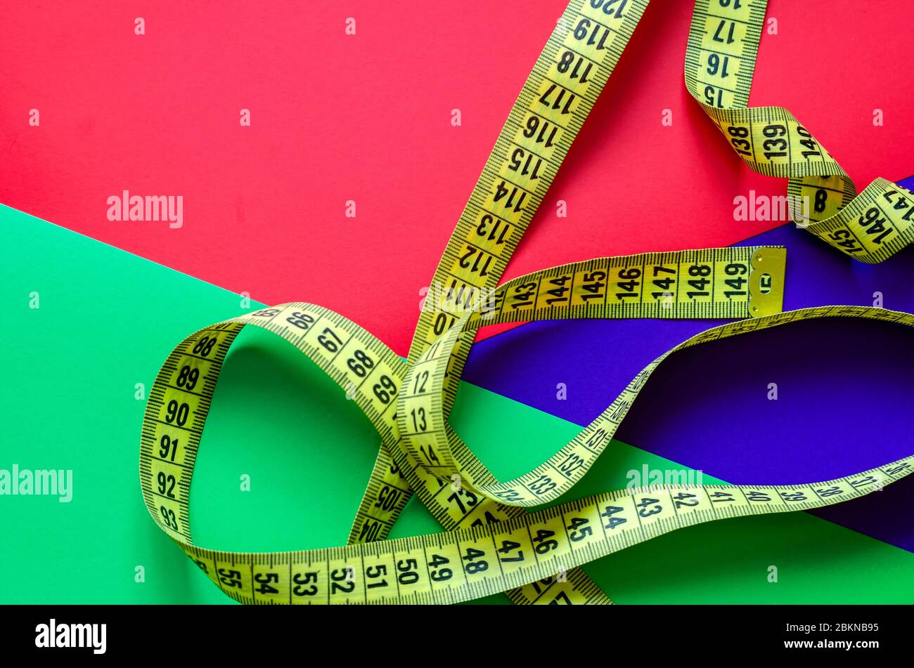 Measuring tape on a colorful background. Yellow tailor meter on a three ...